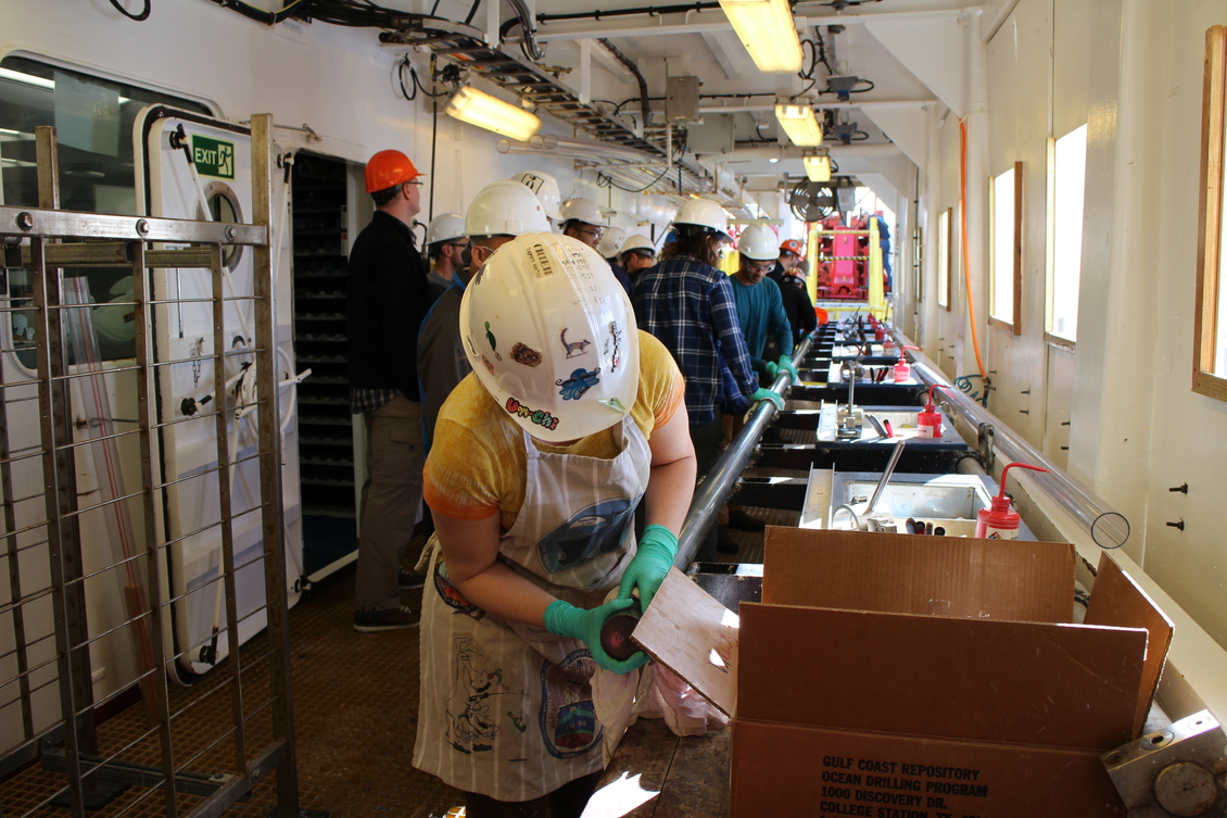 Scientist with a core of sediment on board JOIDES Resolution — Science Learning Hub